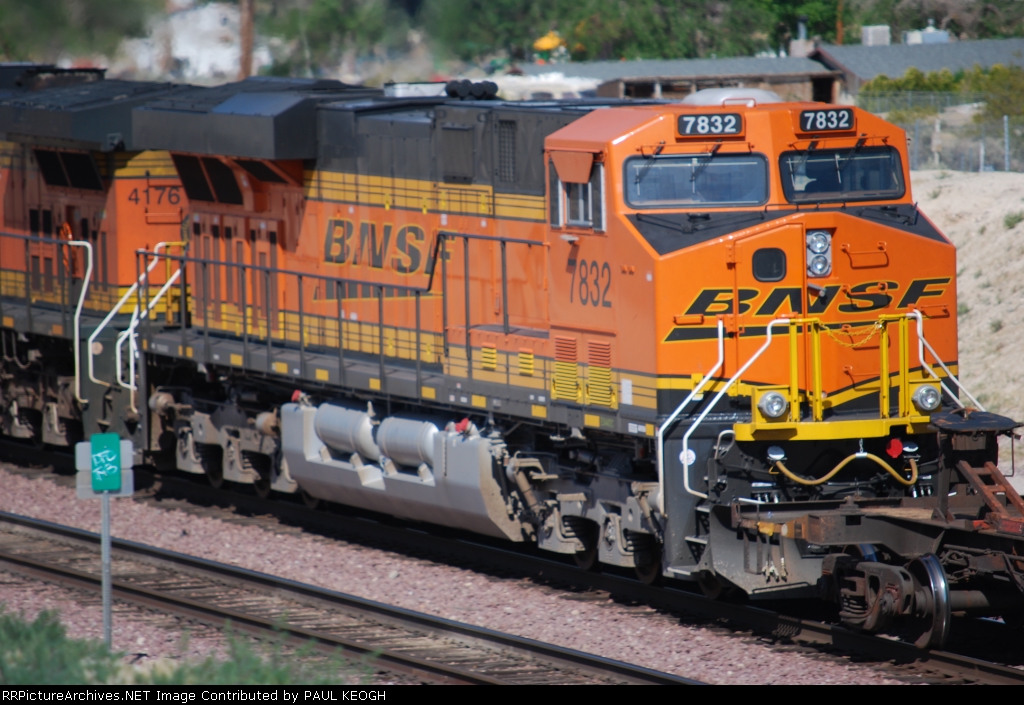 BNSF 7832 rolls west as a # 2 unit behind BNSF 4176 with a bare table train.